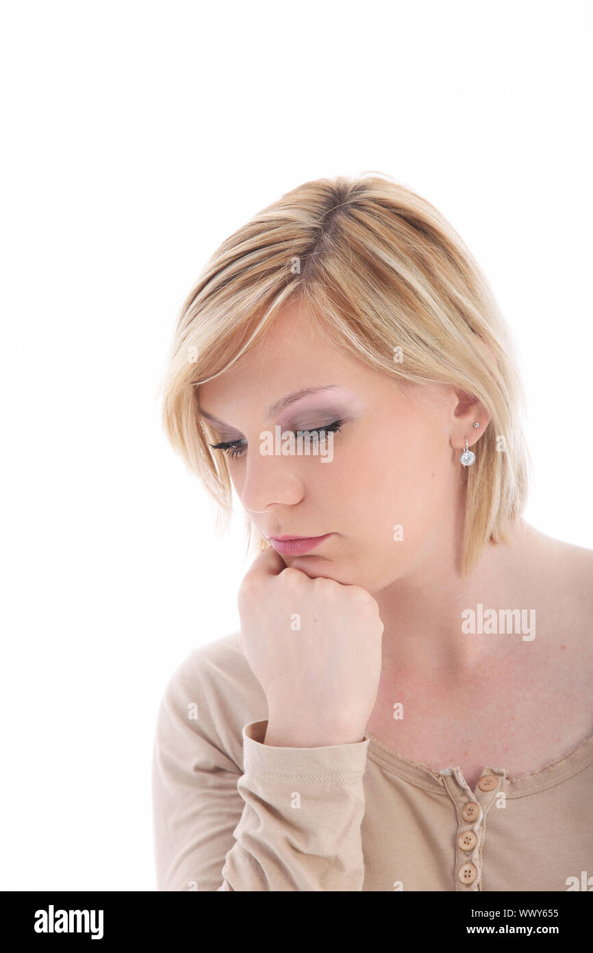 Sad dejected young woman with her chin resting on her hand as she ...