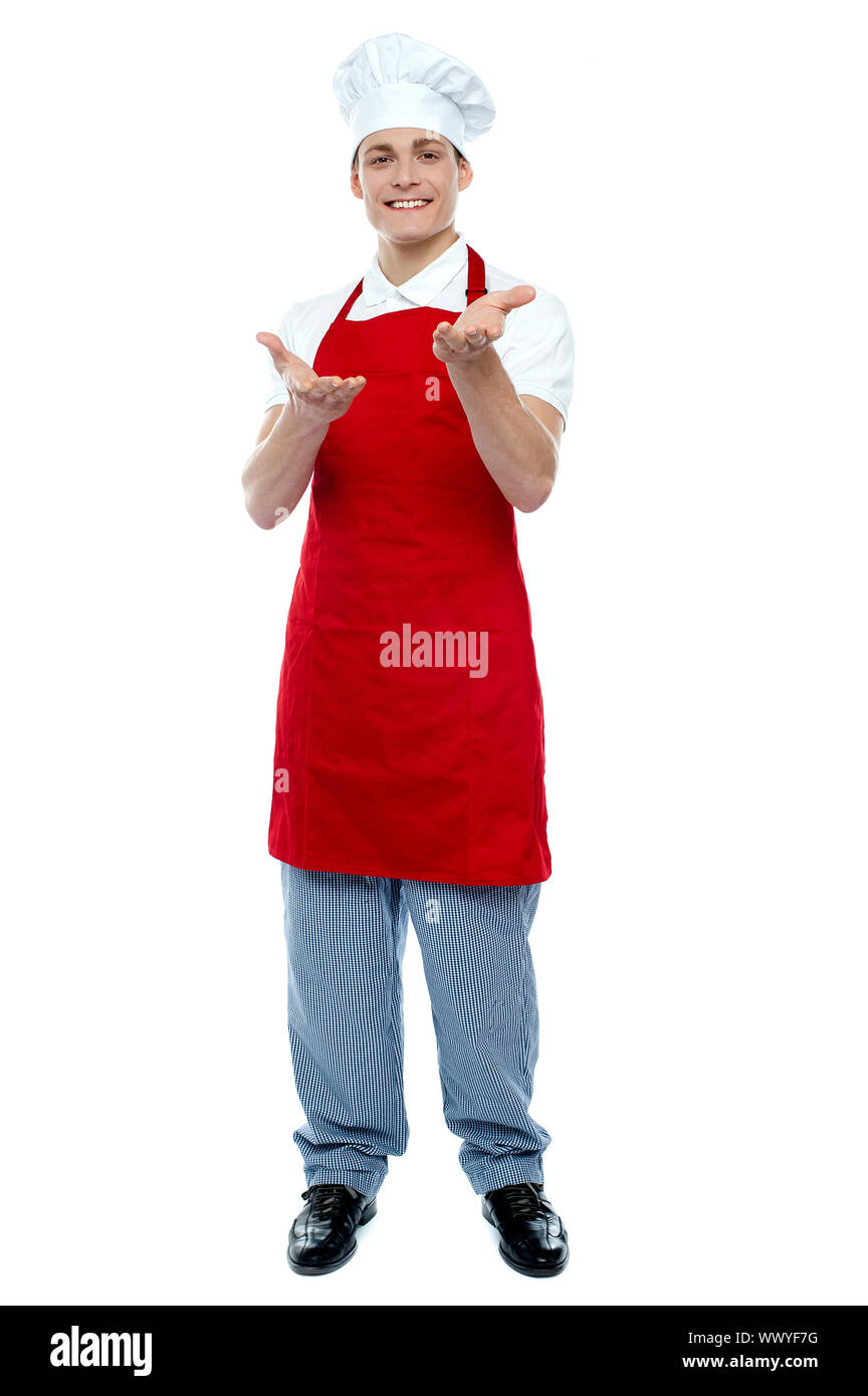Full length portrait of handsome male cook welcoming you. At your ...