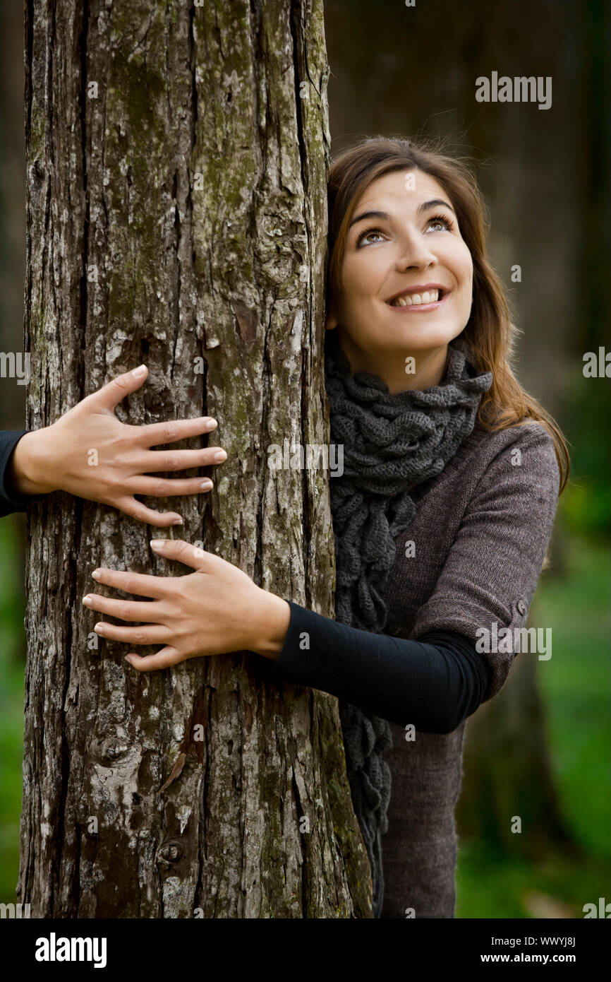 Portrait of a beautiful young woman hugging a tree in fall season Stock ...