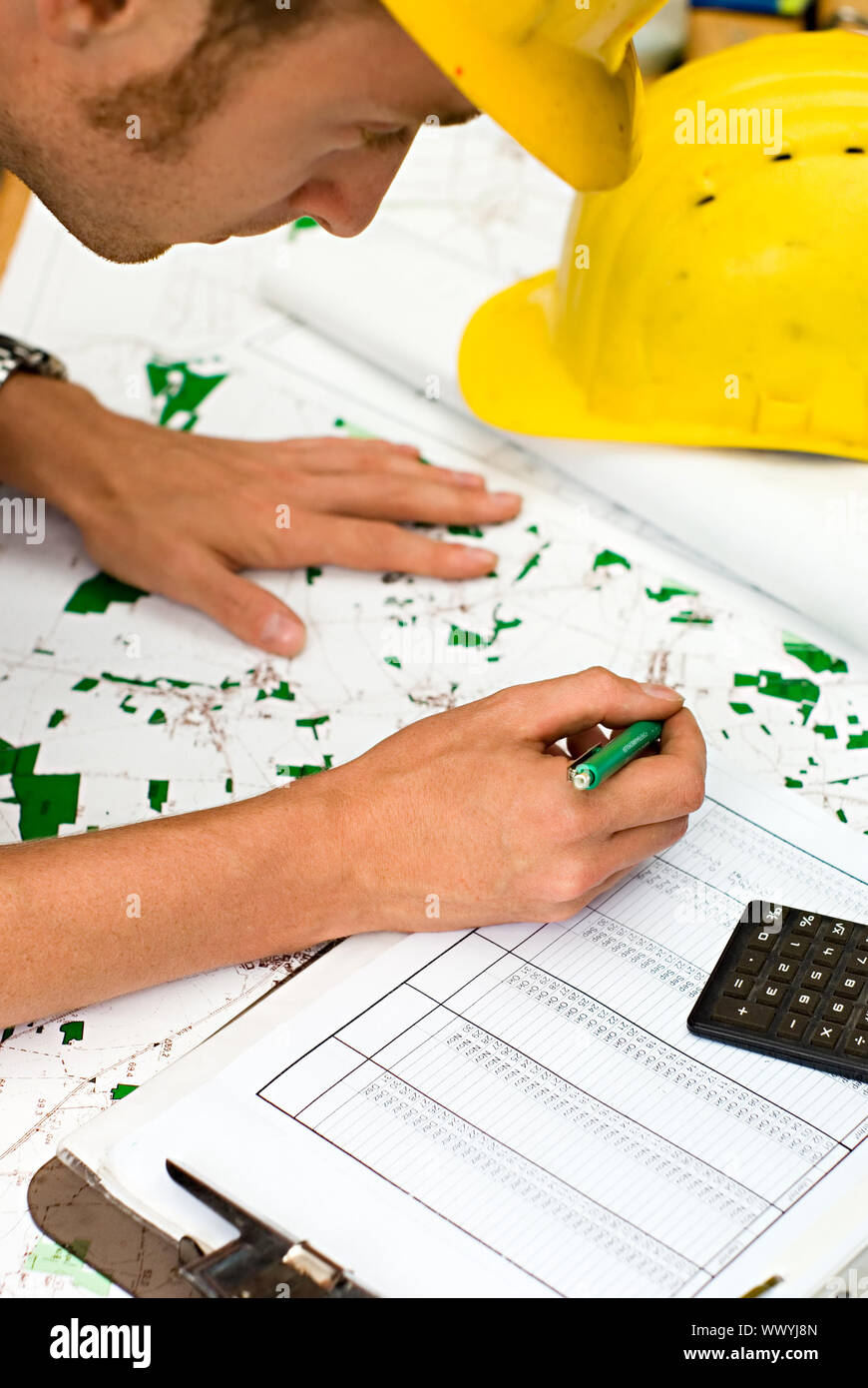 construction worker checking calculating and documents, maps and charts ...