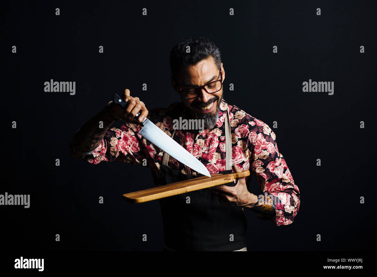 Portrait of a man with cutting board and butcher knife, isolated in a ...