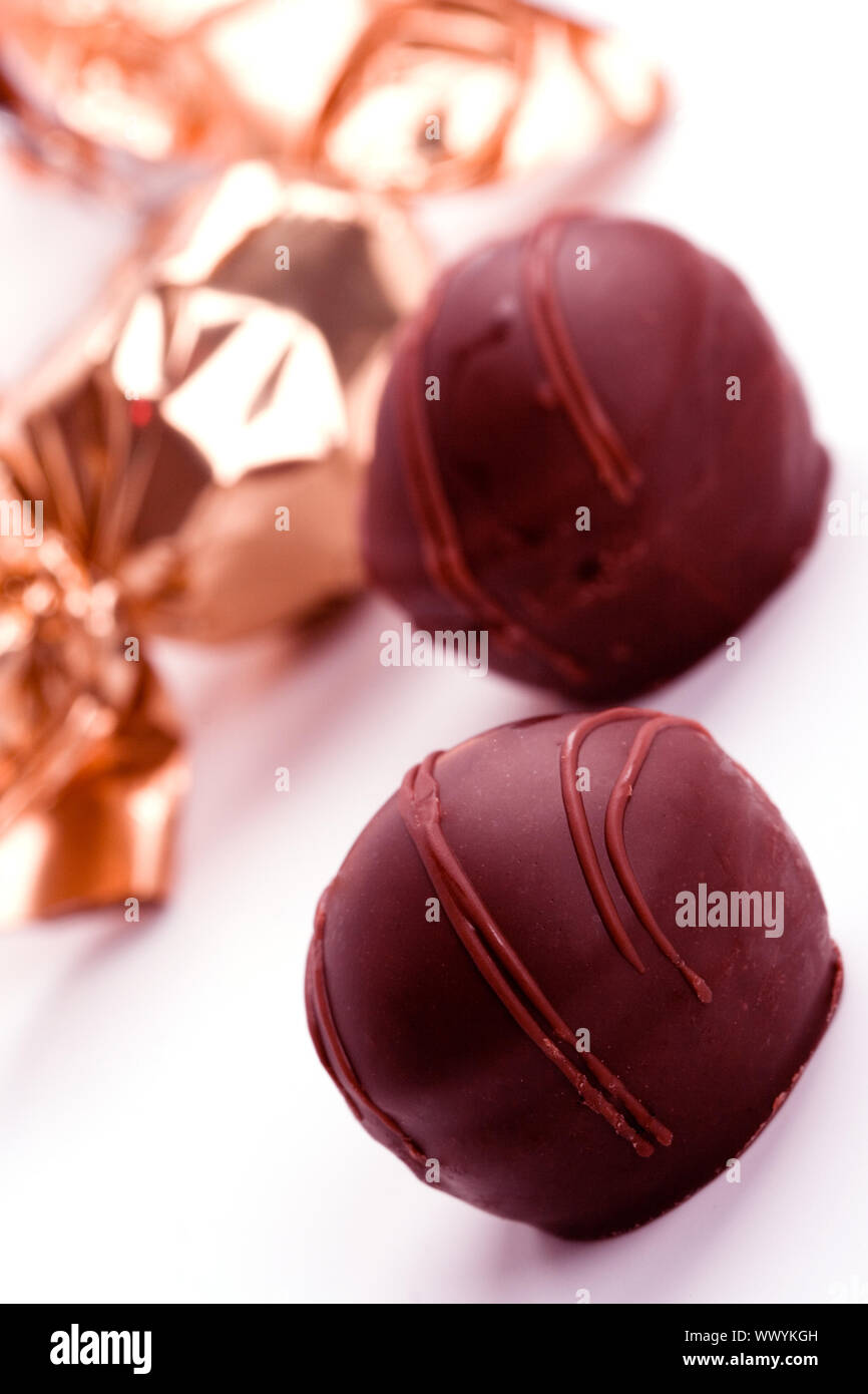 two chocolate foil opened sweets on white background Stock Photo - Alamy