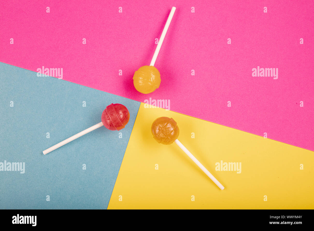 Lollipop candies in row on colored backgrounds top view and one ...