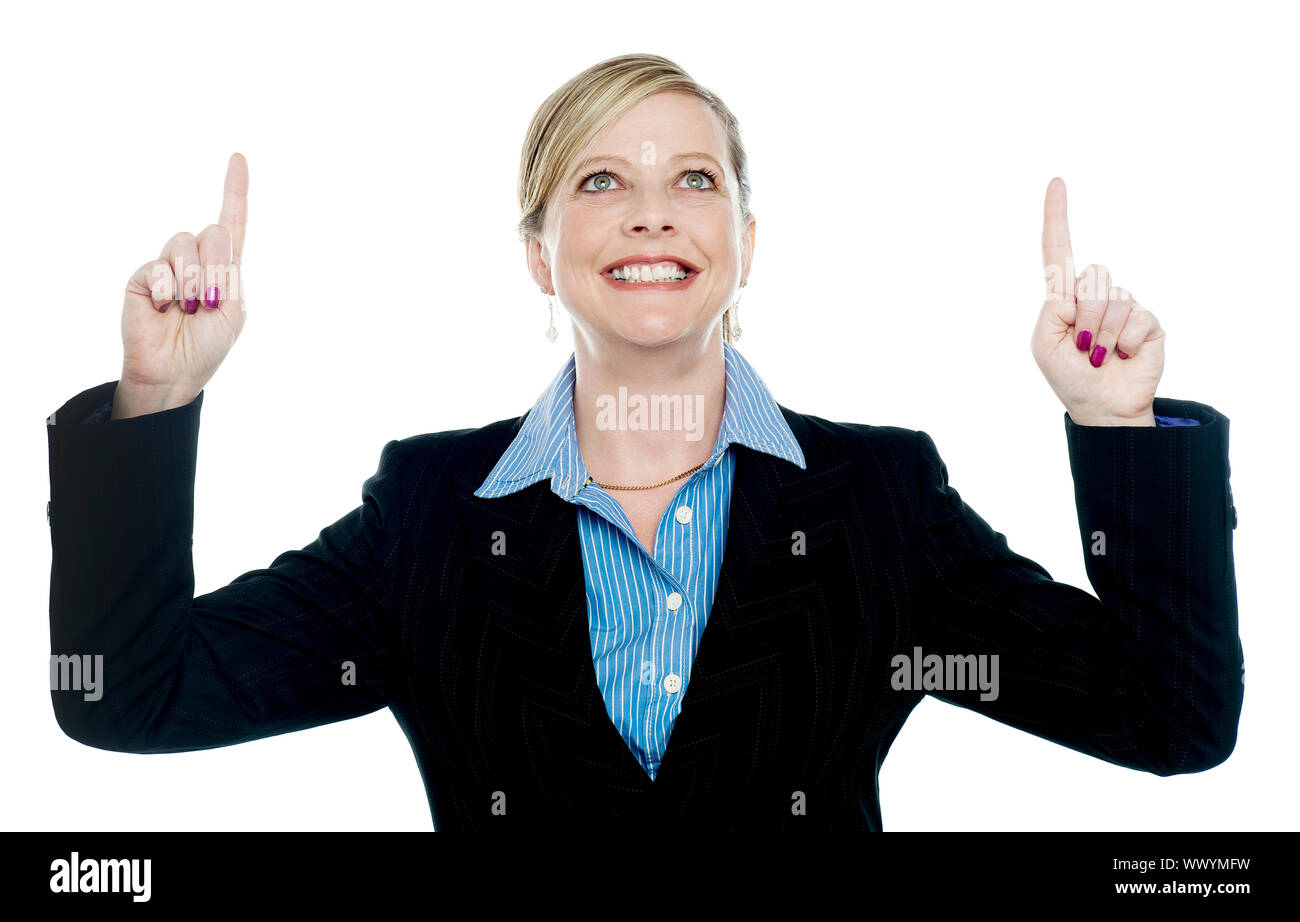 Corporate lady pointing upwards with both hands and looking up as well ...