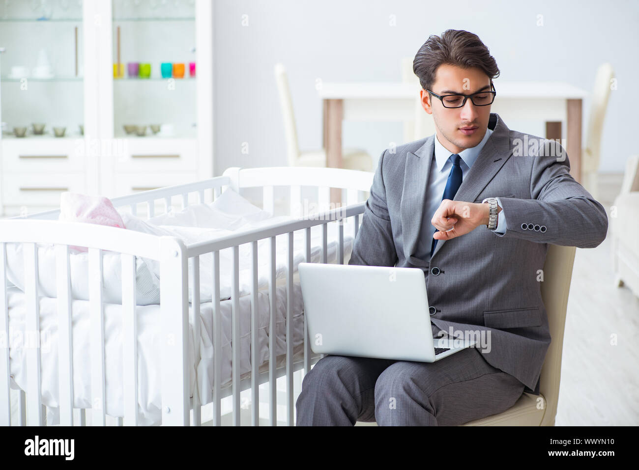 Young businessman trying to work from home caring after newborn baby ...