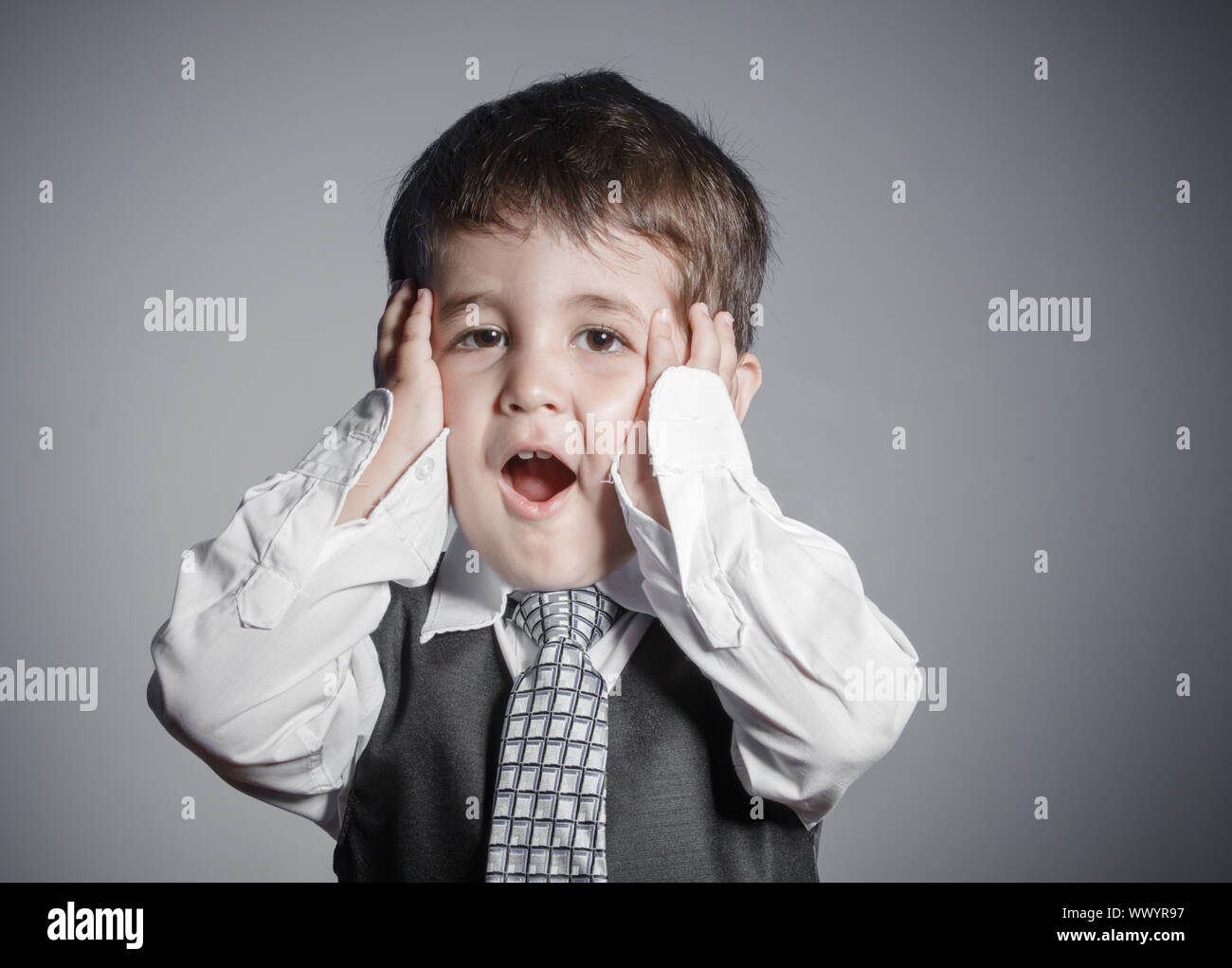 little businessman, brown-haired boy dressed in suit and tie with faces ...