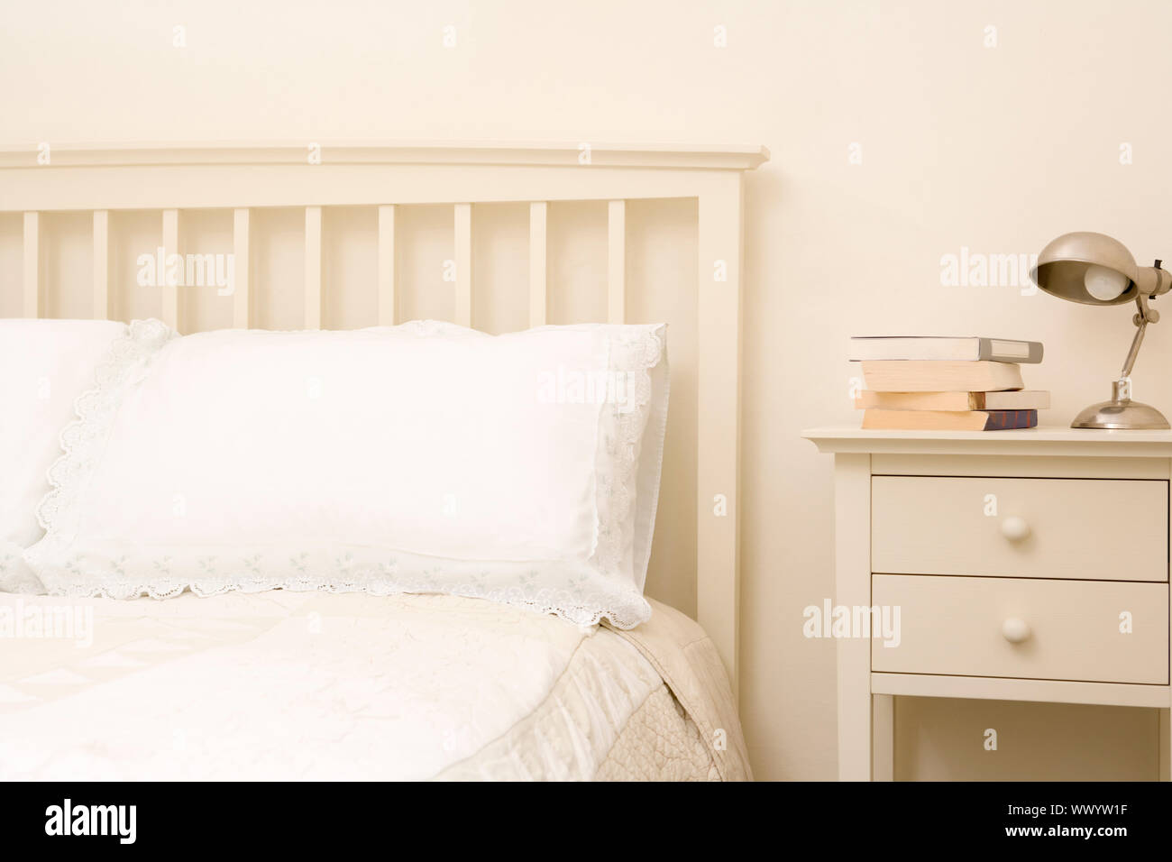 Empty bedroom with books on nightstand Stock Photo - Alamy