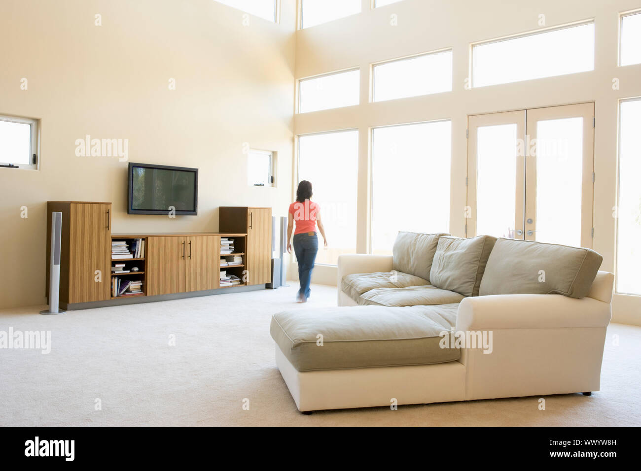 Woman walking through living room Stock Photo - Alamy