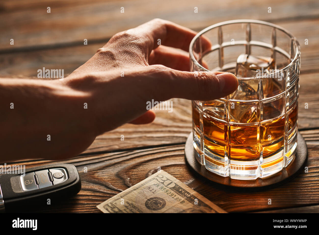 Man's hand reaching to glass with alcohol drink and car key. Drink and ...
