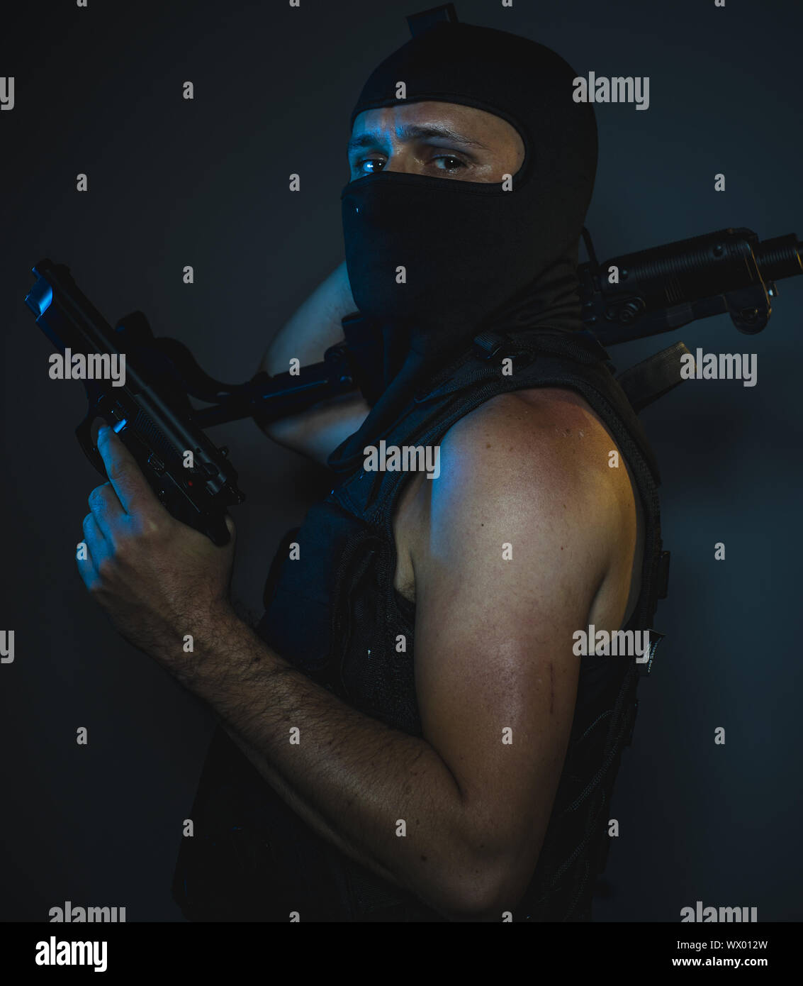 Mafia hit man, armed and dangerous man with balaclava and bulletproof ...