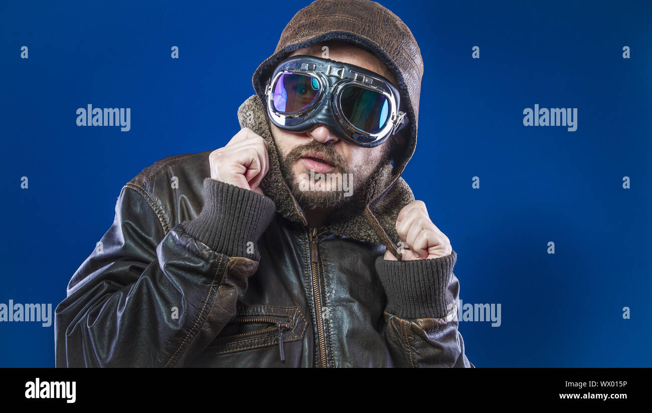 pilot of the 20s with sunglasses and vintage aviator helmet. Wears ...