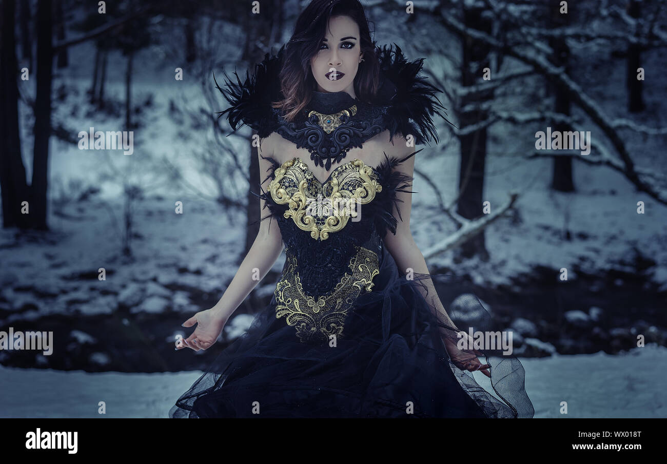 Dark queen, Beautiful brunette woman with gothic dress made in gold and ...