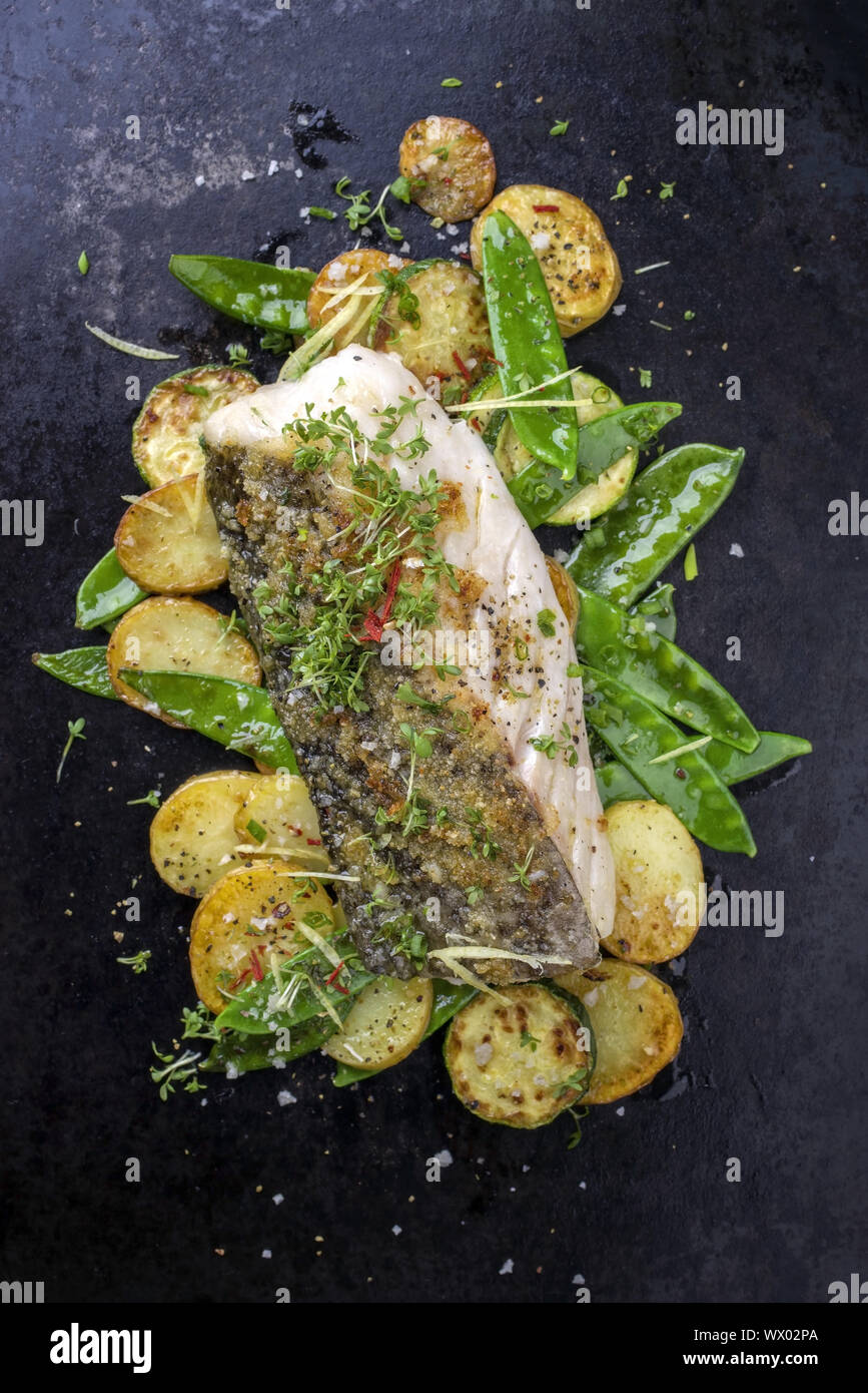 Fried cod fish fillet with vegetable and potatoes as top-view on old ...