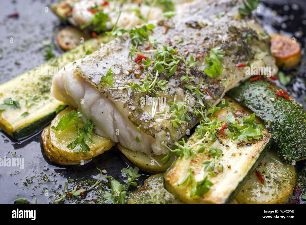 Fried cod fish fillet with vegetable and potatoes as top-view on old ...