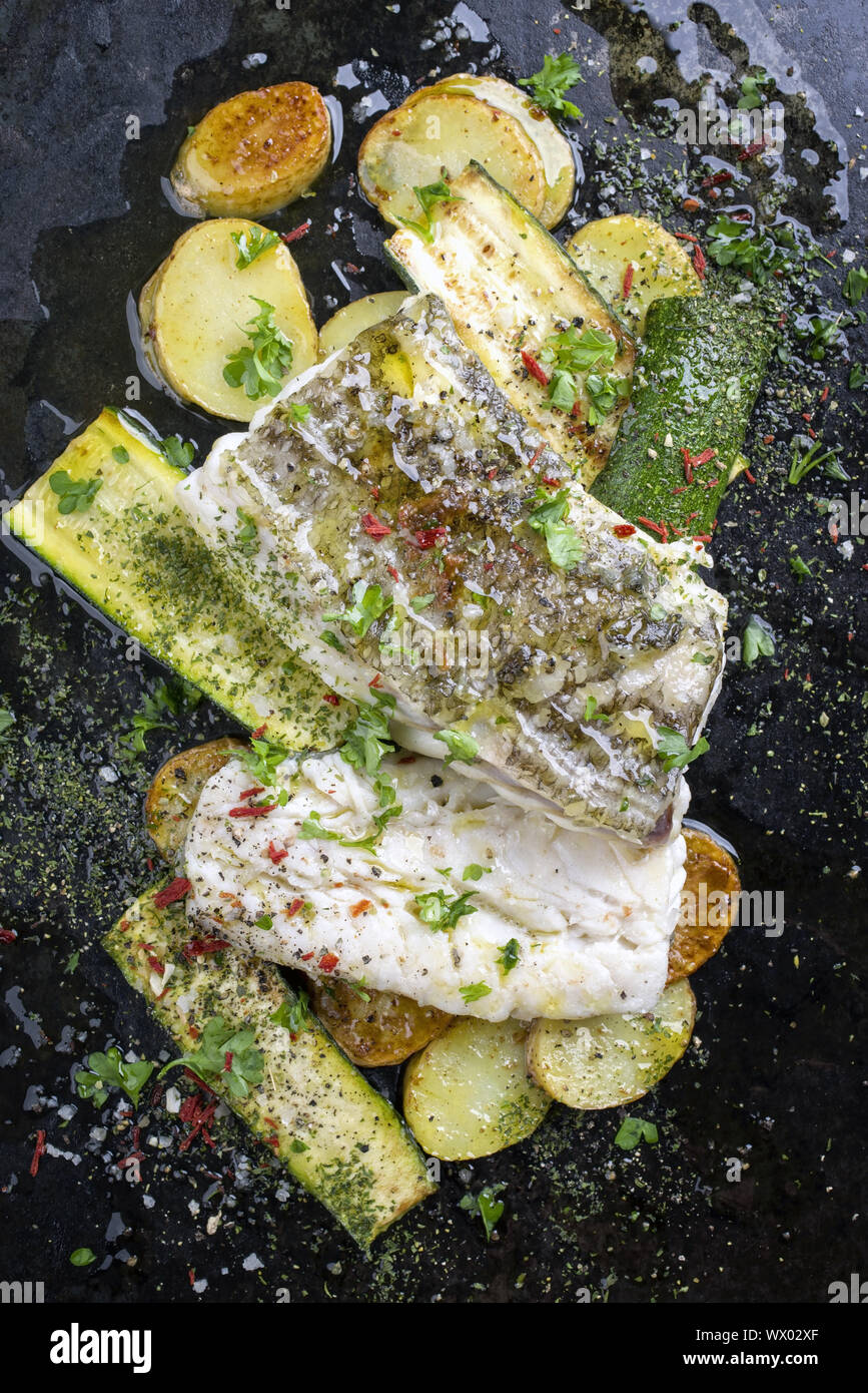 Fried cod fish fillet with vegetable and potatoes as top-view on old ...