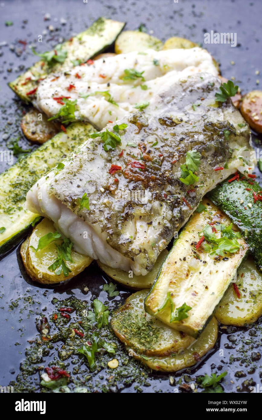 Fried cod fish fillet with vegetable and potatoes as top-view on old ...