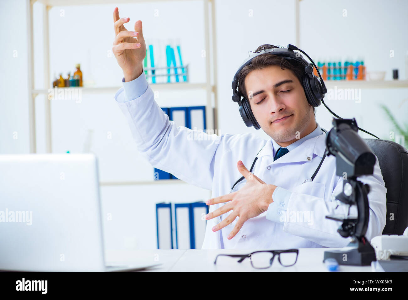 Happy excited doctor listening to music during lunch break in hospital ...