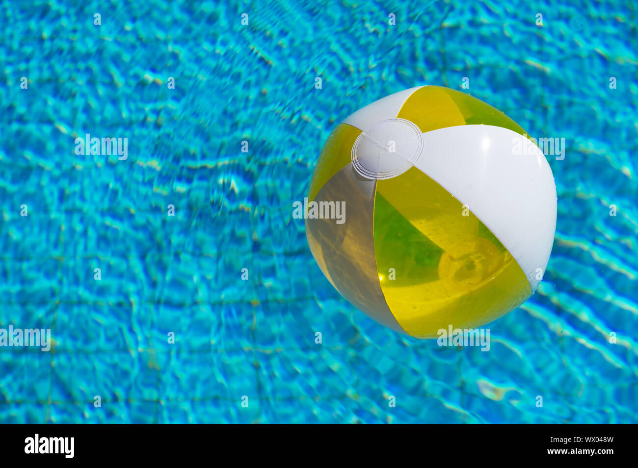 Inflatable yellow beachball floating at the water Stock Photo - Alamy