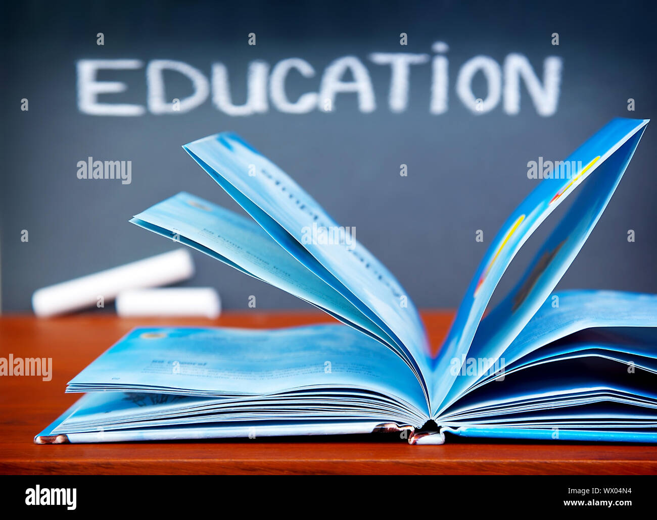 Education concept, open book on the desk in the classroom, chalkboard ...
