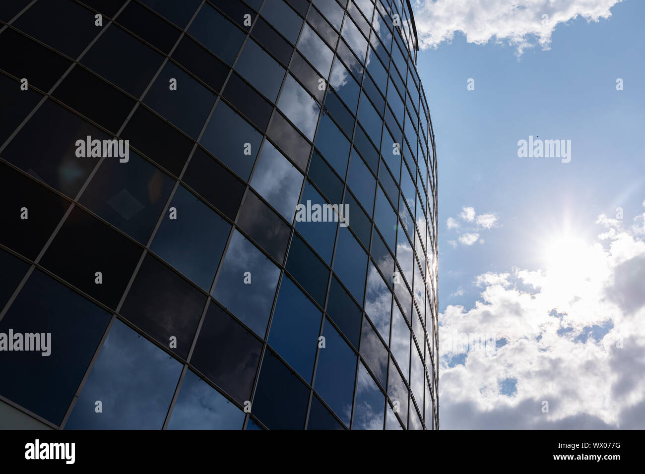Low angle view of modern glass building facade in downtown, sky ...