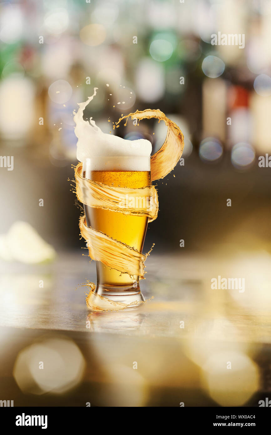 A cold glass of beer and a splash around on a blurred bar counter ...