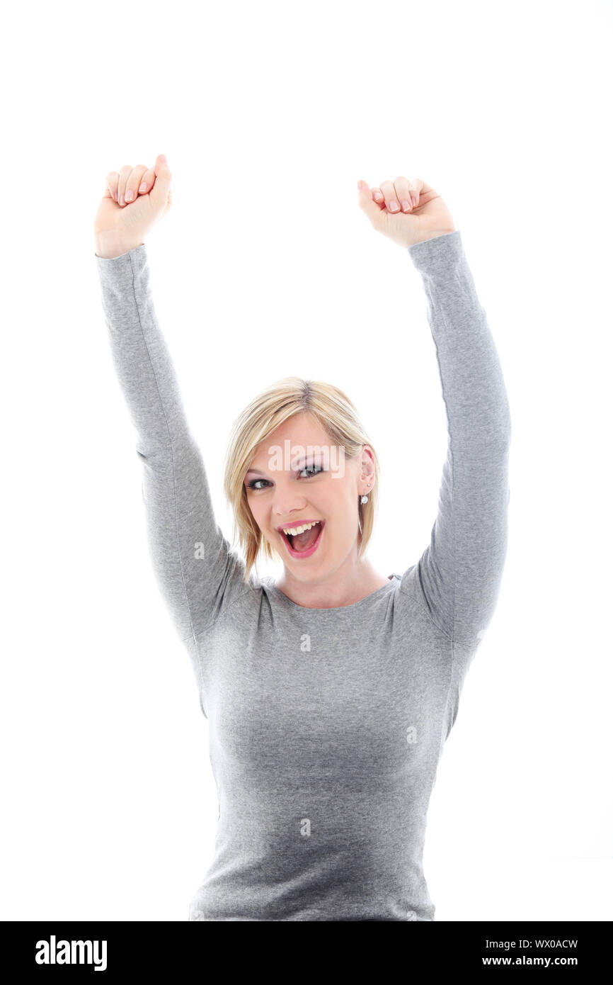 Jubilant young woman raising her arms above her head in celebration of ...