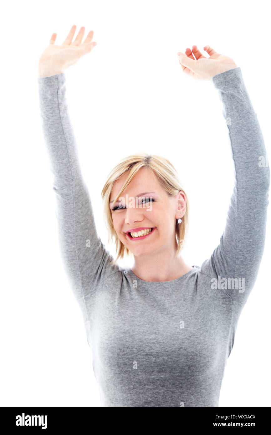Successful beautiful young woman beaming with pleasure raising her arms ...