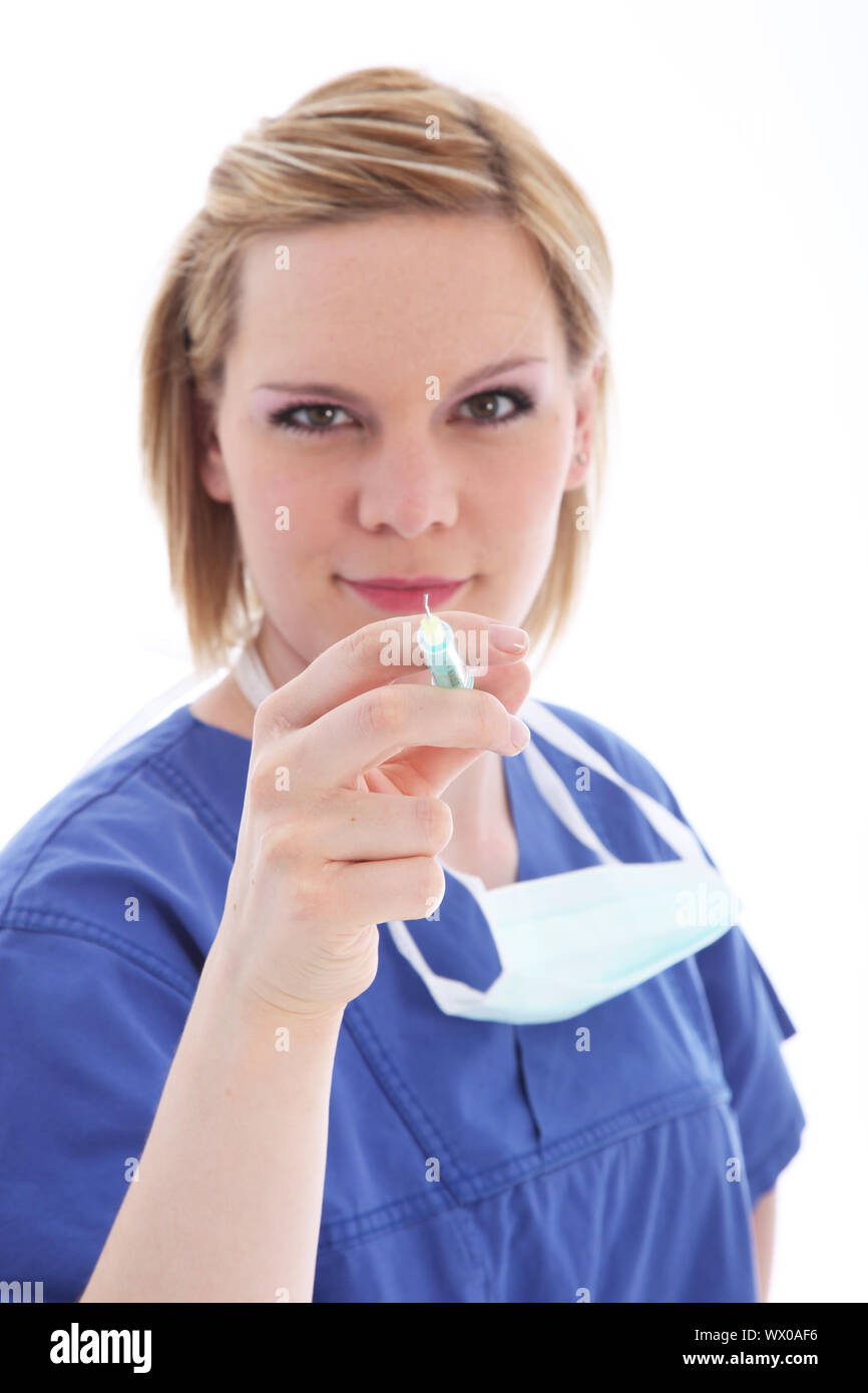 Nurse in blue scrubs standing holding the hypodermic and needle ready ...
