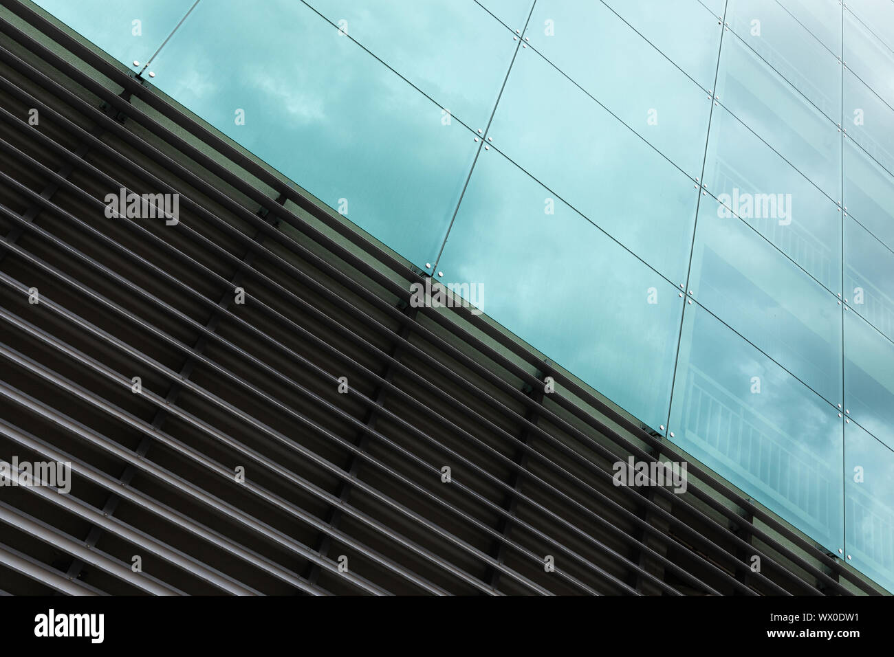 Diagonal view of modern wall surface, glass and metal texture with sky ...