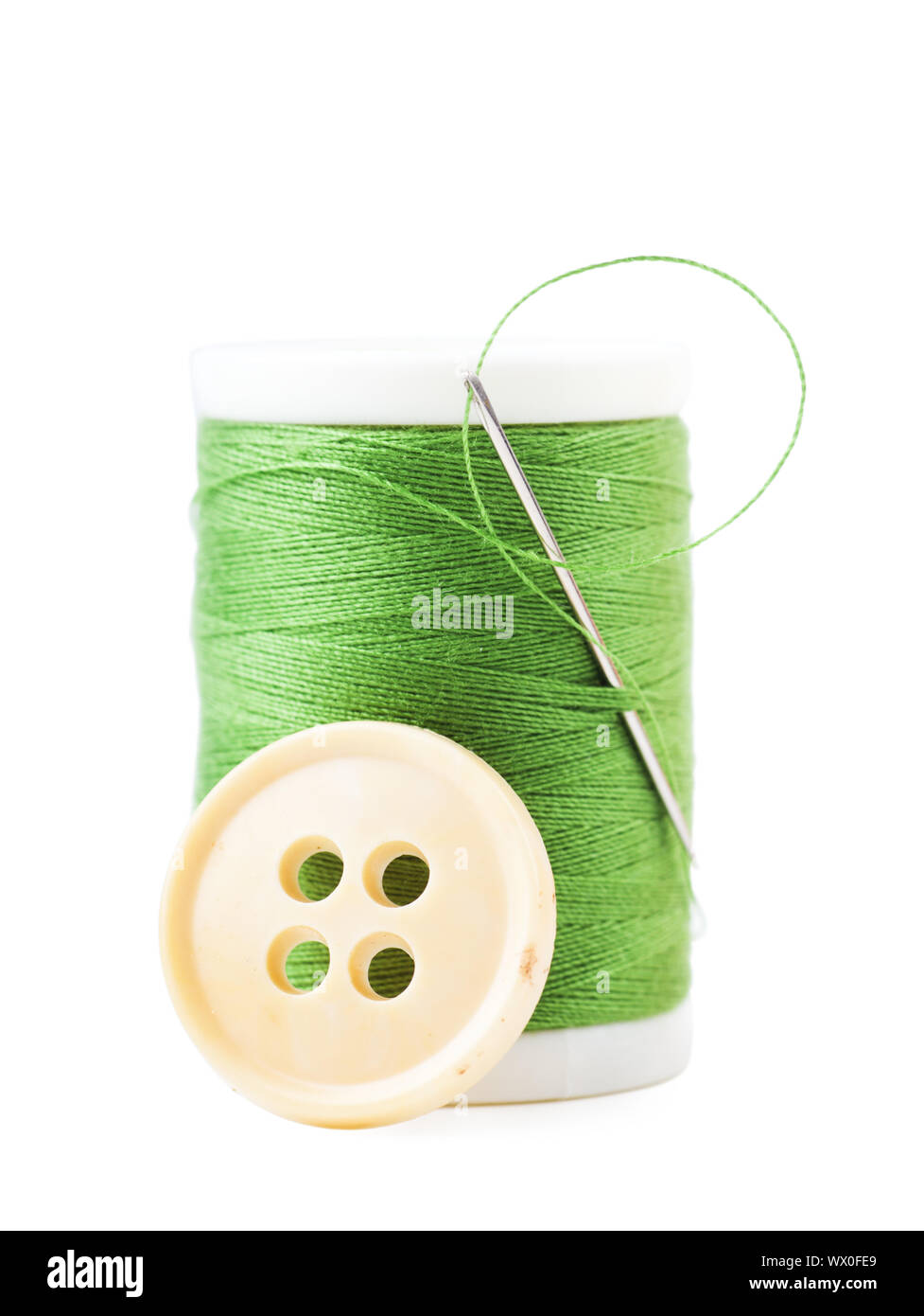 Single spool with green thread and needle Stock Photo - Alamy