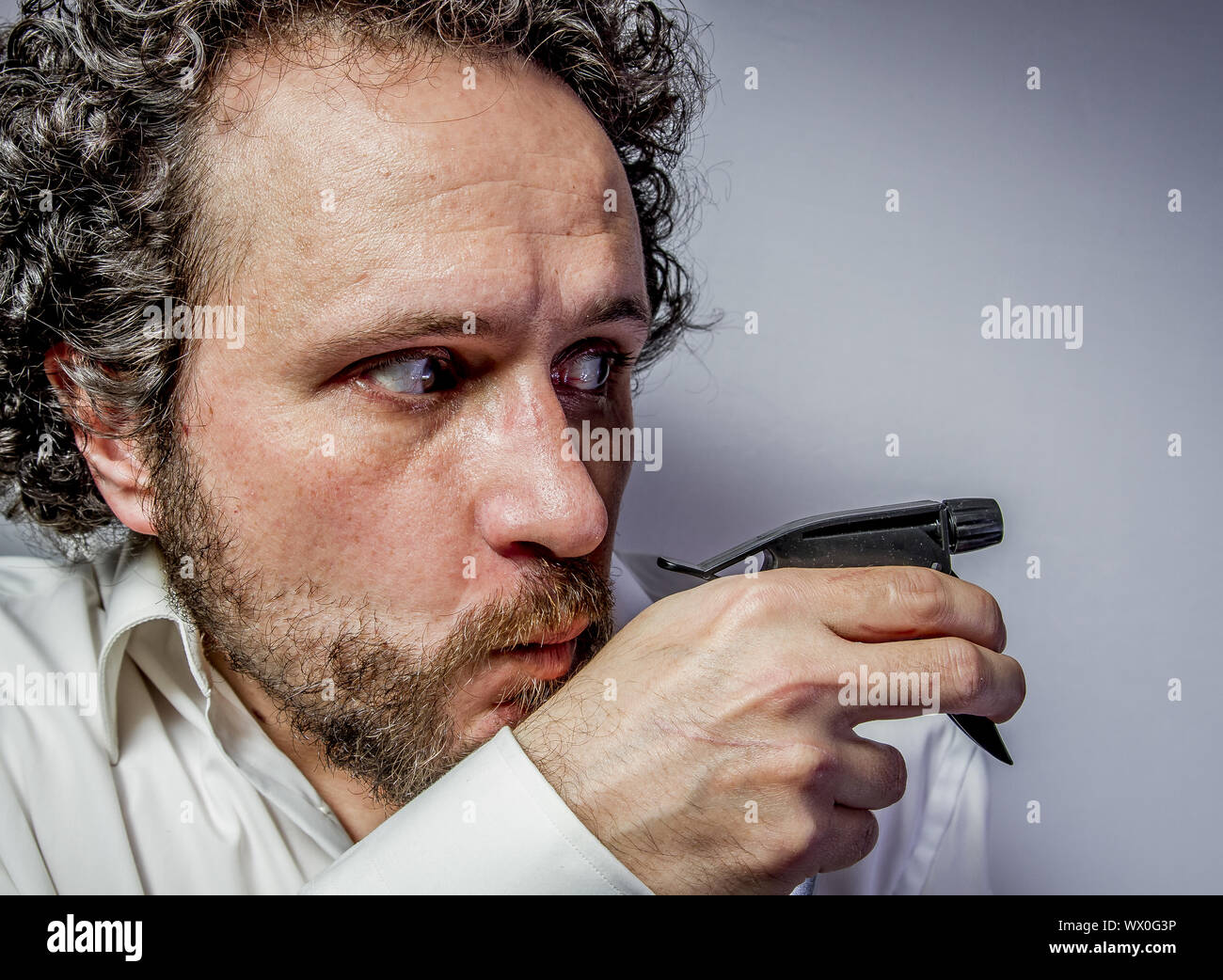 cleaning spray, man with intense expression, white shirt Stock Photo ...