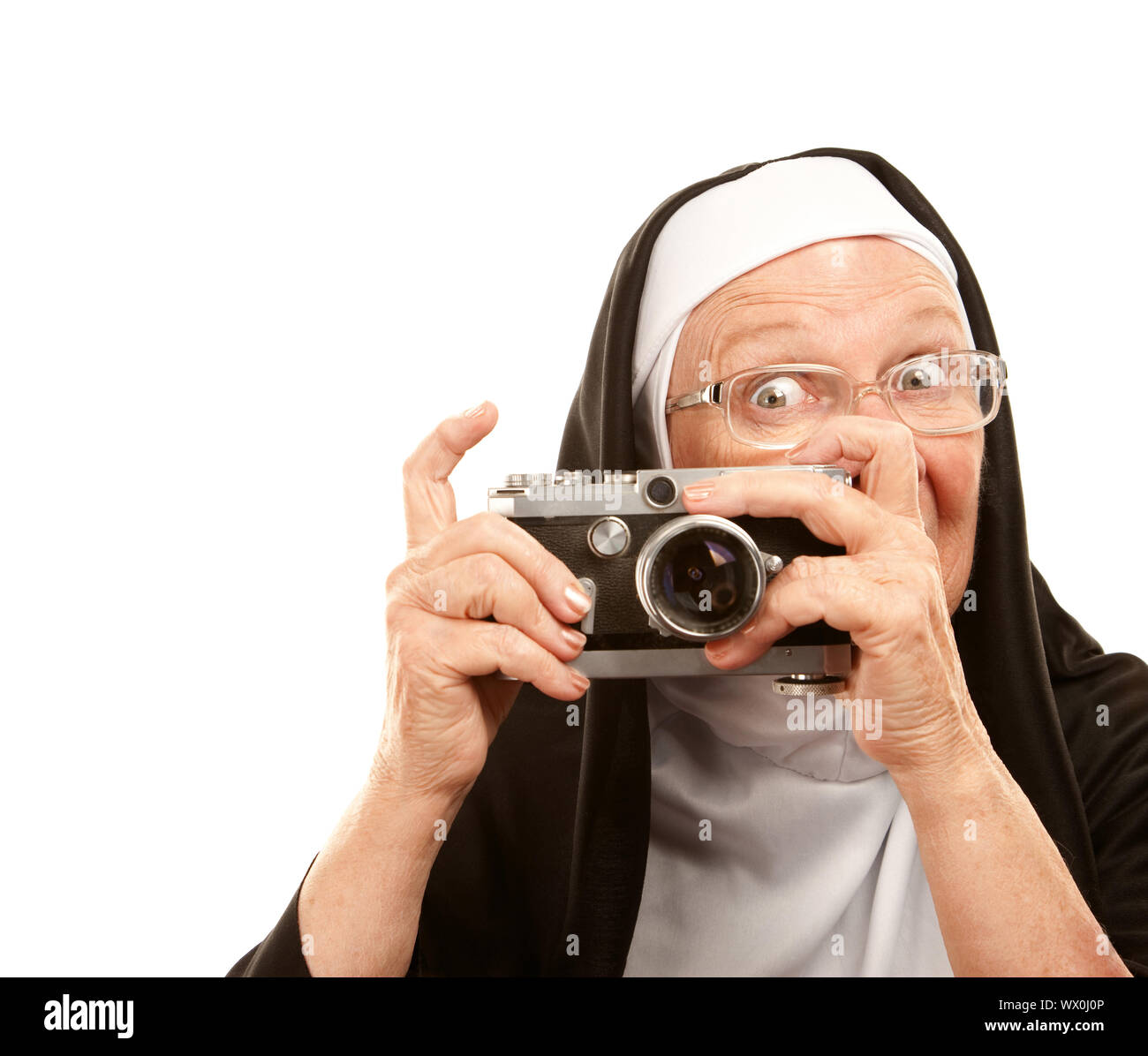 Funny nun taking photograph with a vintage camera Stock Photo - Alamy