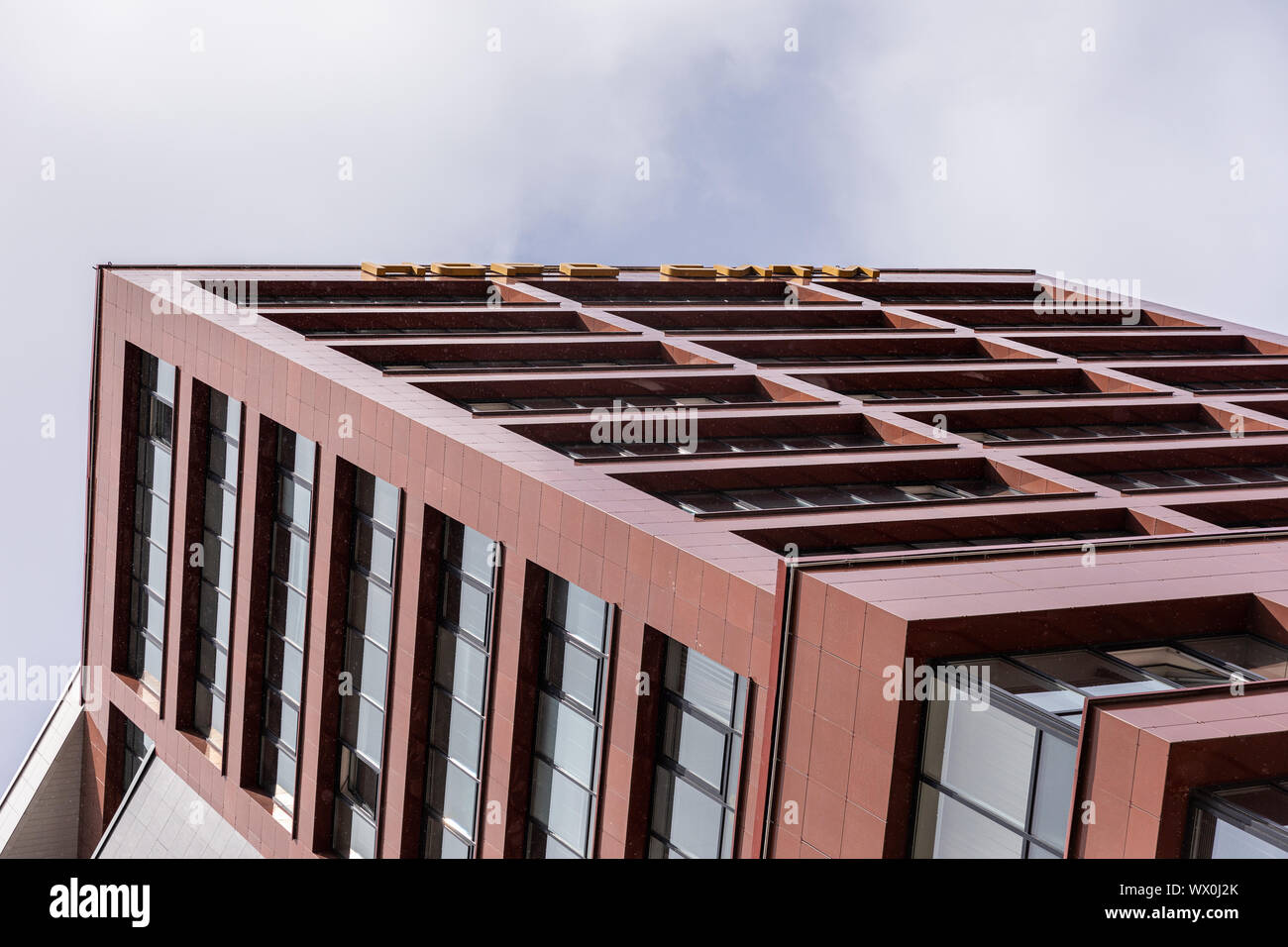 Ground view of modern apartment facade, building corner with windows ...