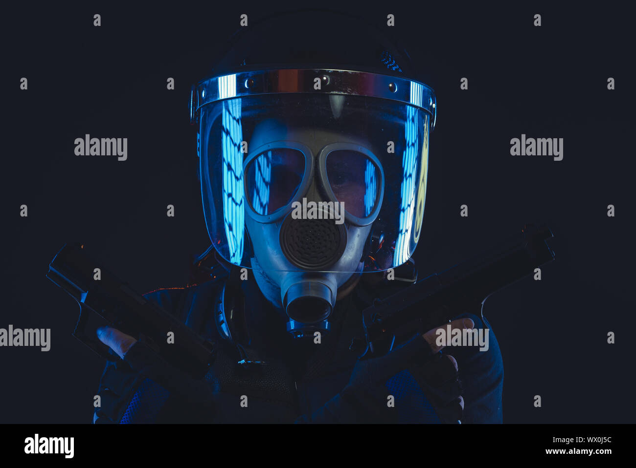 Special unit policeman in a gas mask and shield, isolated on black ...
