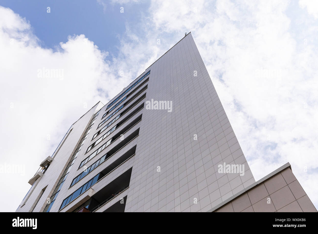 Ground view of high building with gray concrete walls and sky ...