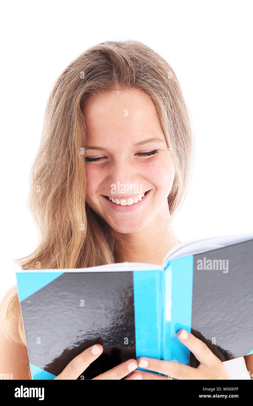 Smiling teenager with a lovley wide smile reading a book which she is ...
