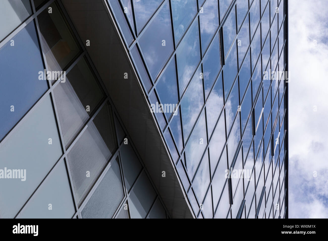 Side view of glass surface on modern building facade with reflected sky ...