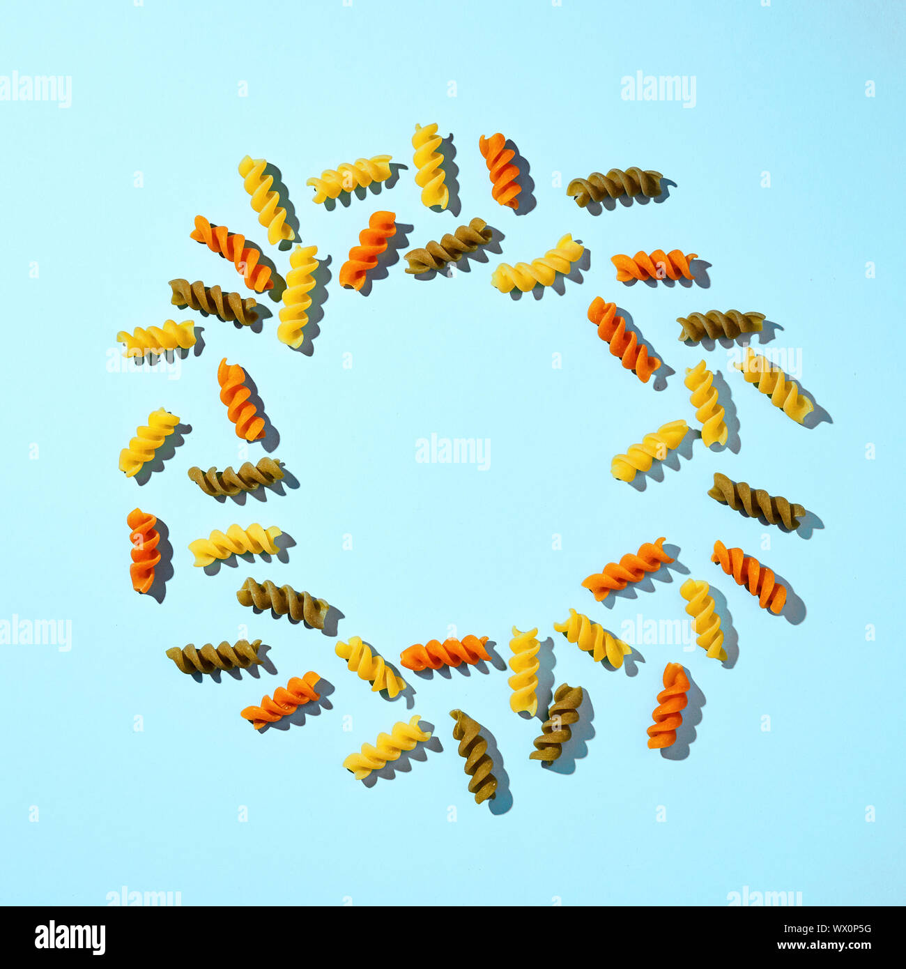 Round frame of macaroni with copy space on a blue background. Flat lay ...