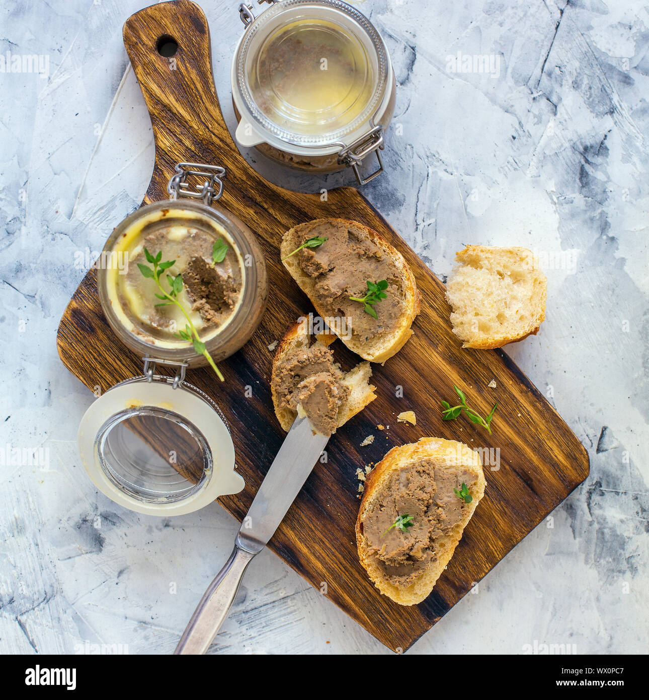 Homemade beef liver pate in a glass jar and baguette slices with pate ...