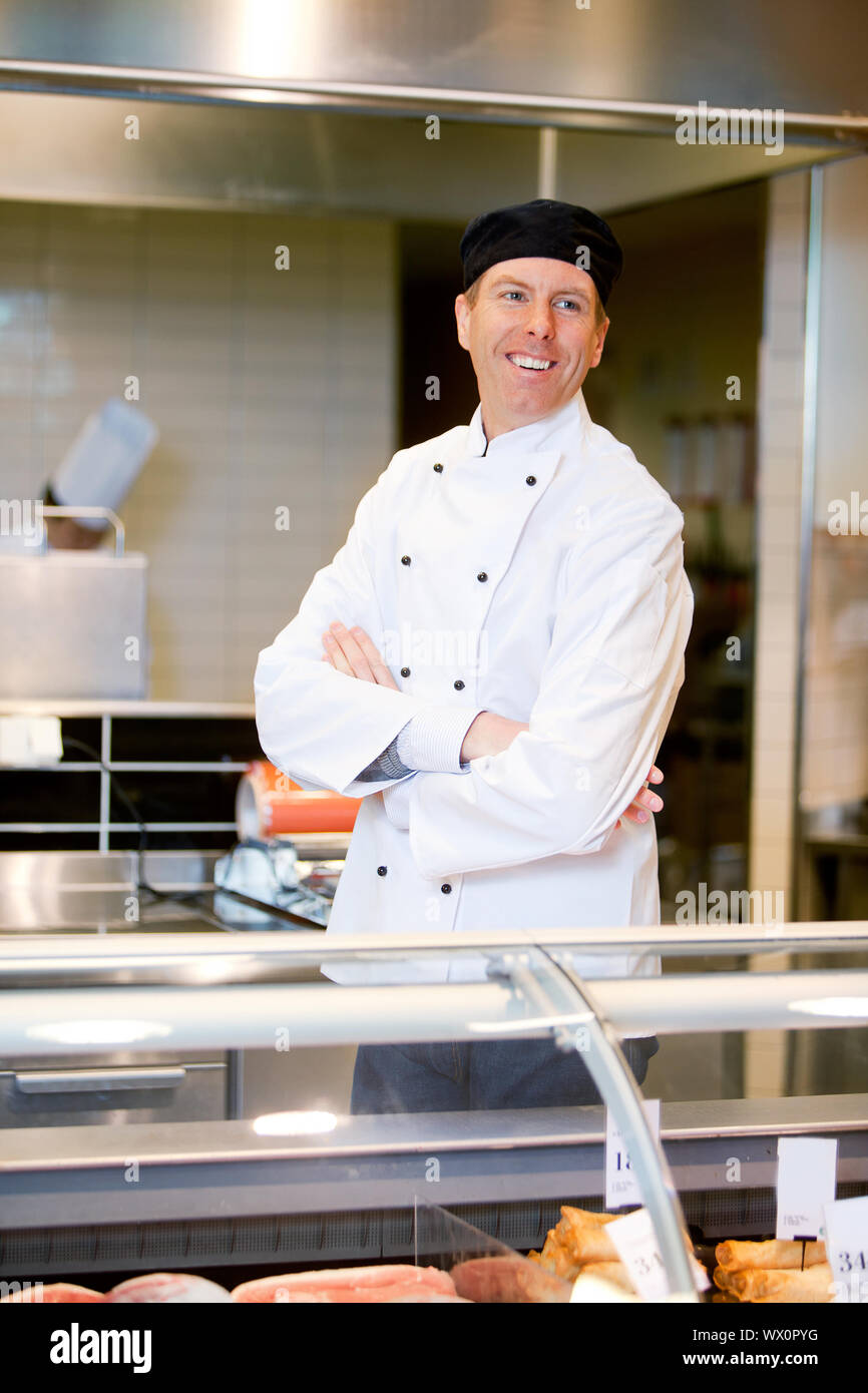 A happy smiling butcher helping a custmer at a fresh meat counter Stock ...