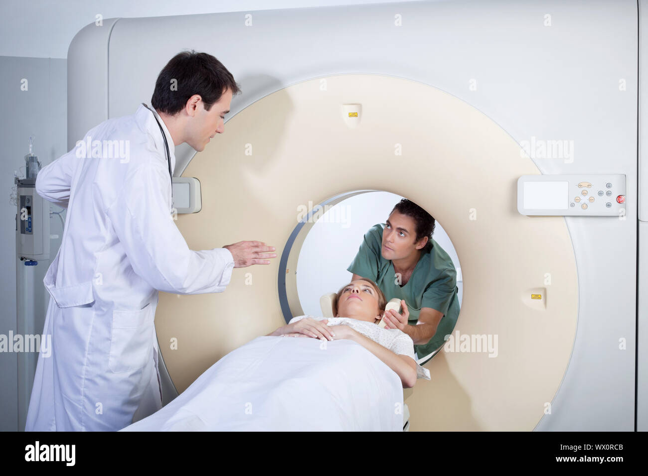 Doctor instructing technician while preparing patient for MRI scan ...