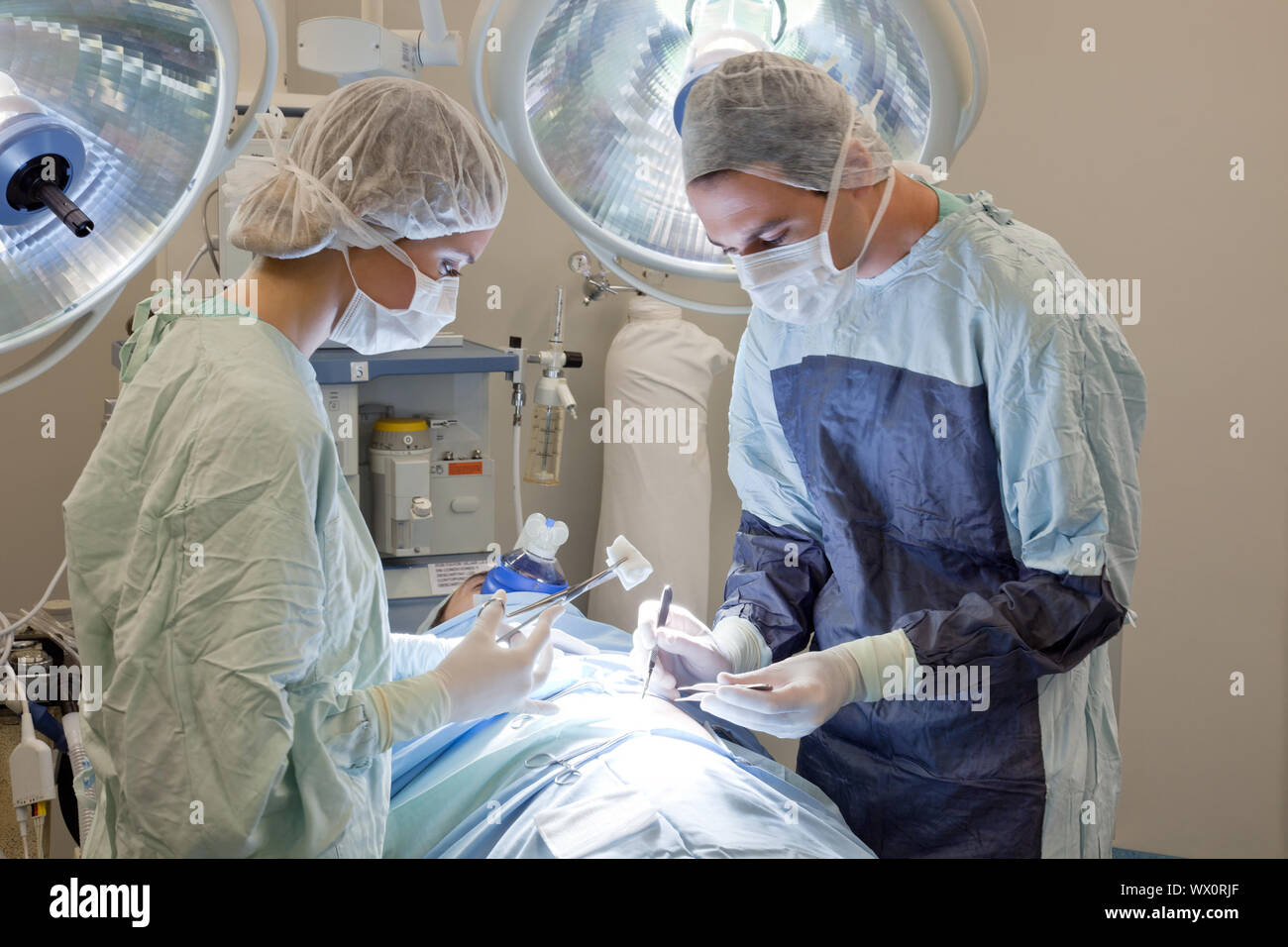 Medical doctor performing an operation on patient in operating room ...