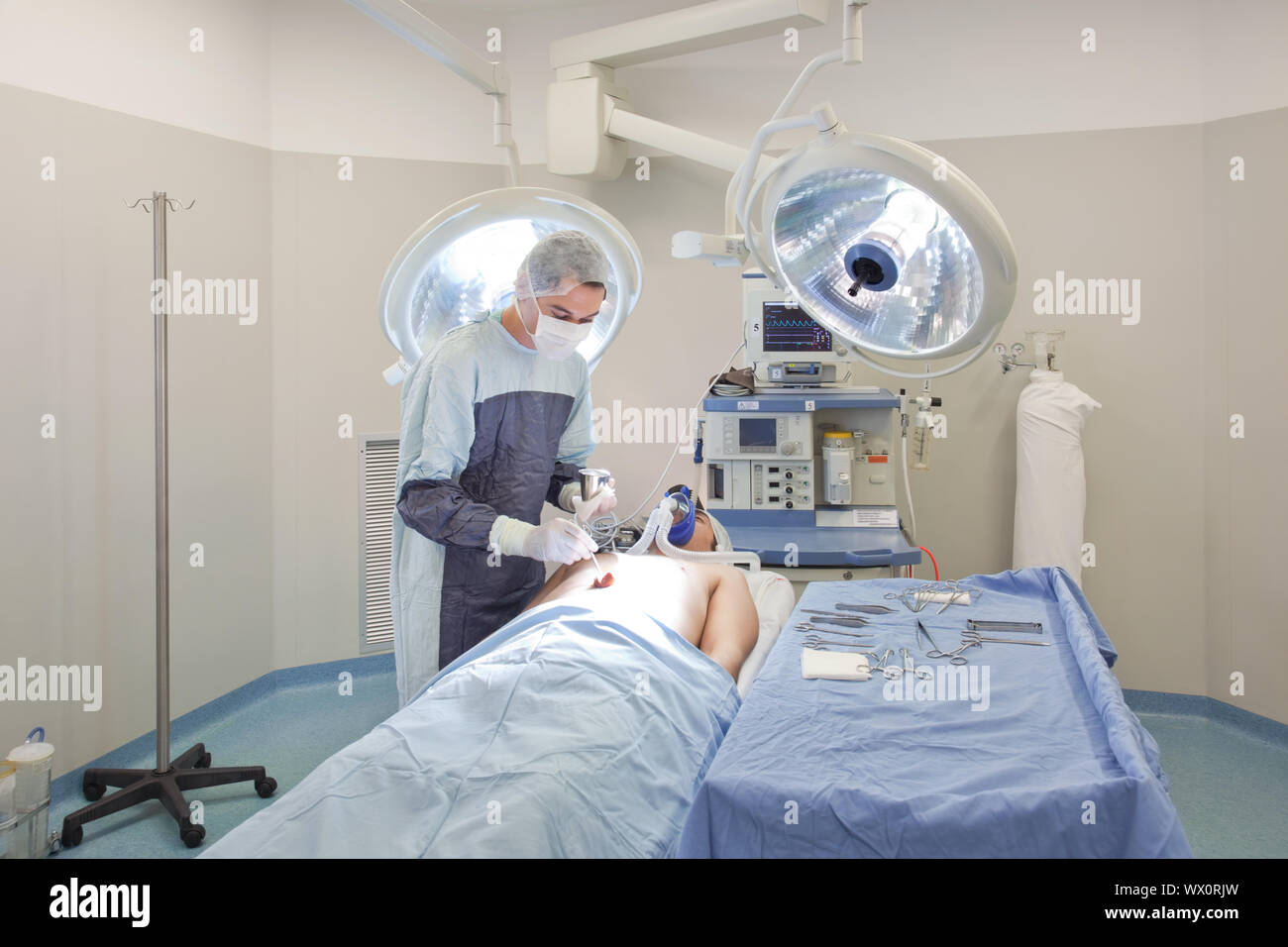 Young doctor performing operation on patient in operating room Stock ...