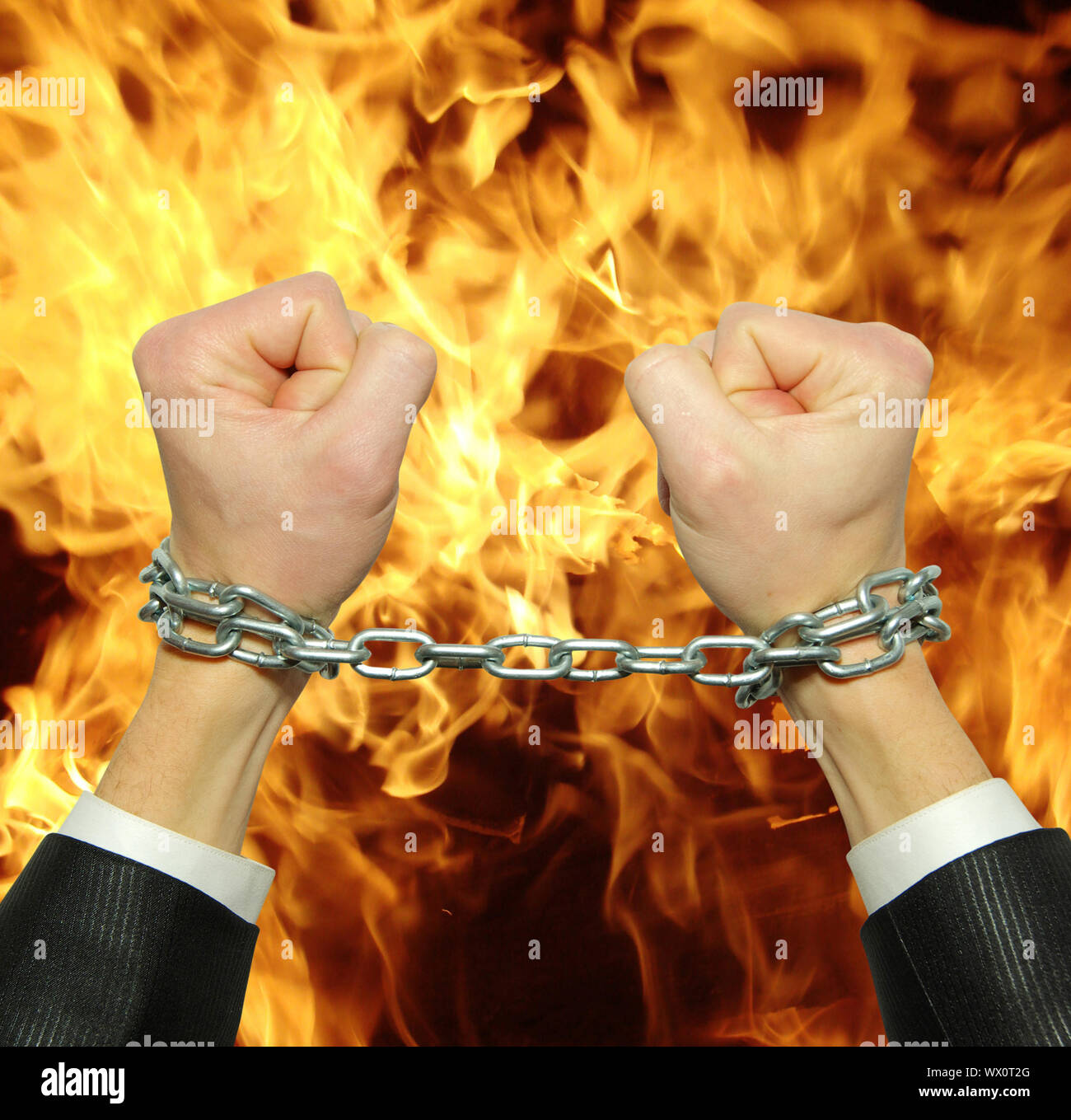 Hands in chains on a fire background Stock Photo - Alamy