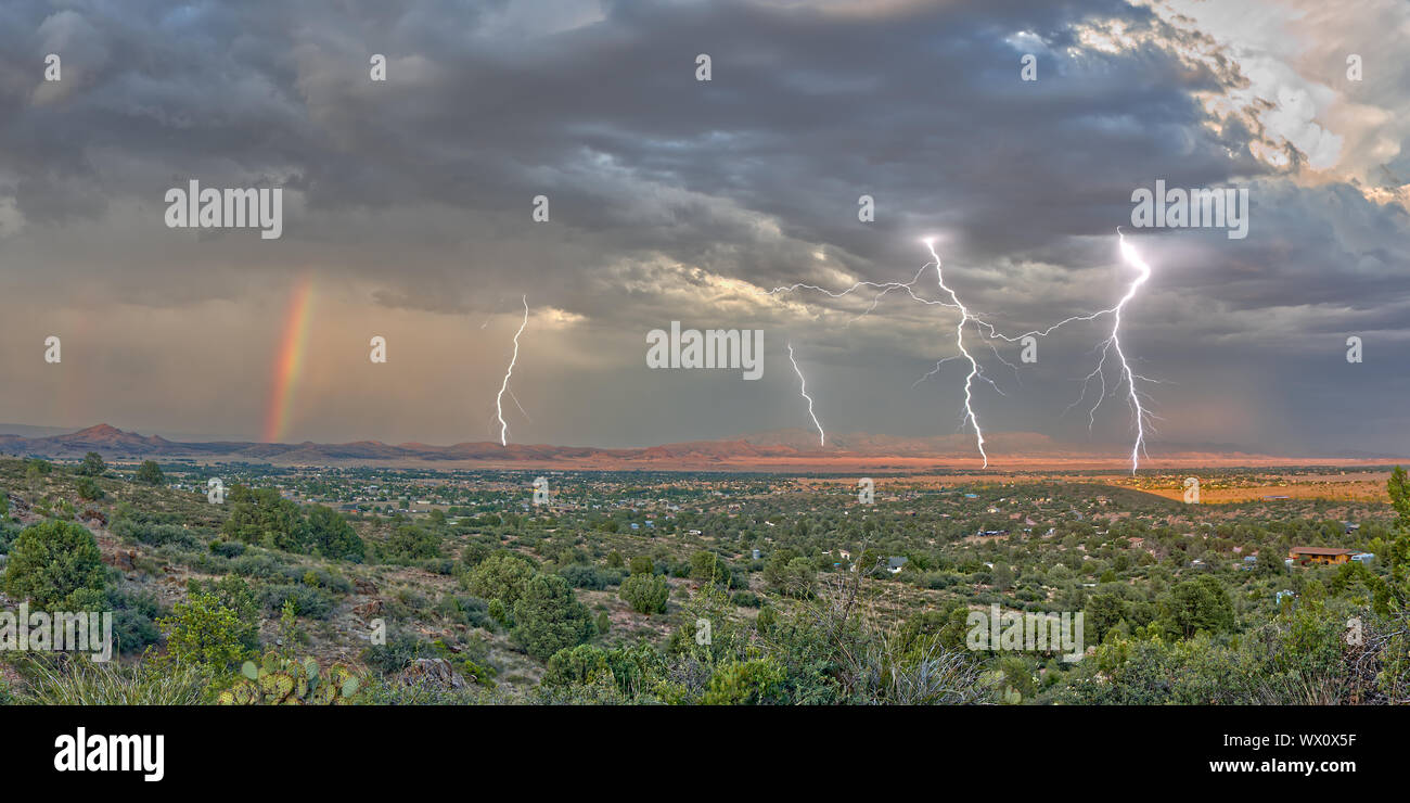 A lightning storm with a rainbow rolling over Mingus Mountain just east ...