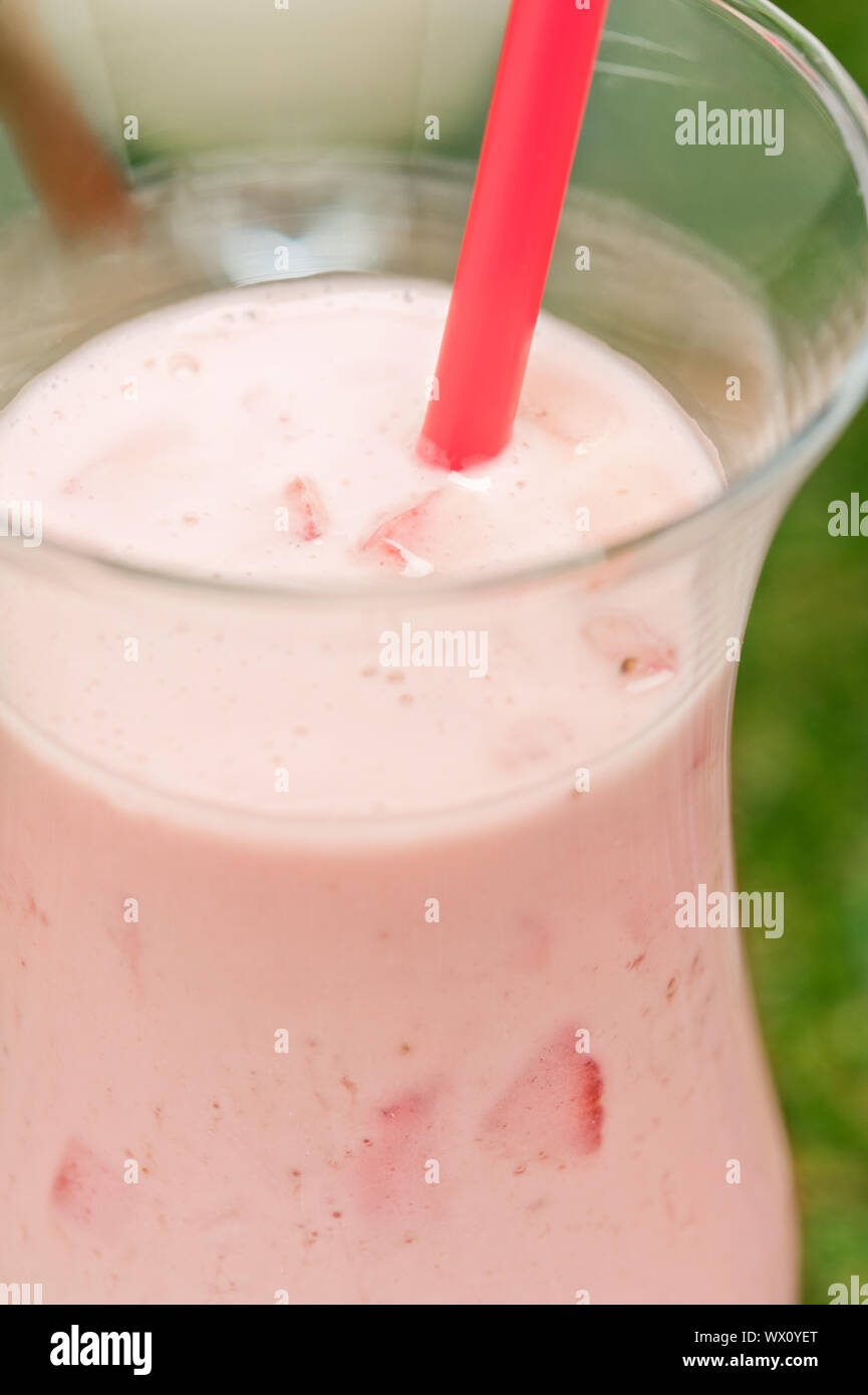 Strawberry milk shake with red straw Stock Photo - Alamy