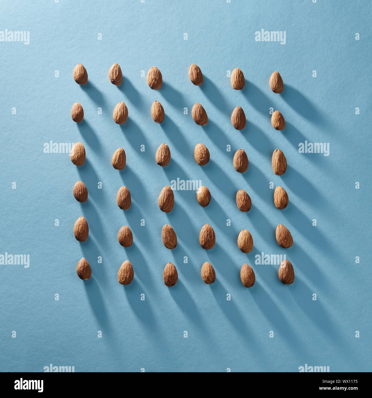 Almonds in a square shape in a blue paper background. Organic food ...