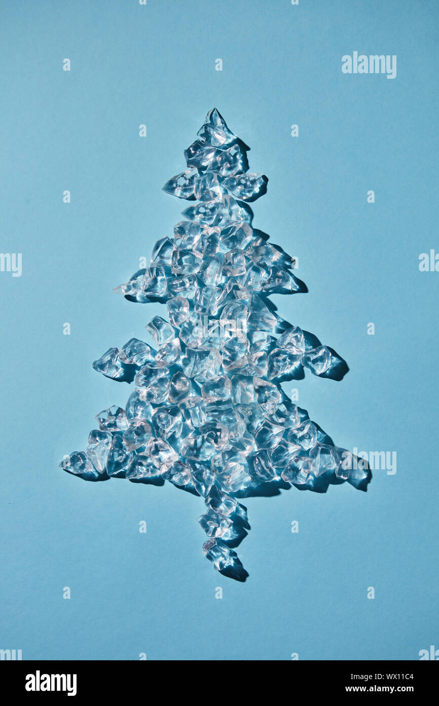Cold ice cubes in the shape of a Christmas tree on a blue background ...