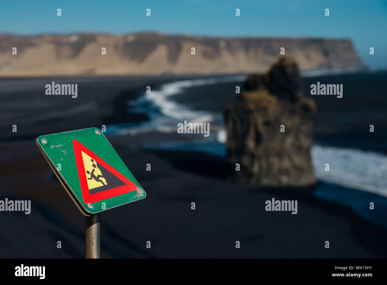 Warning sign in black sand beach, Iceland Stock Photo - Alamy