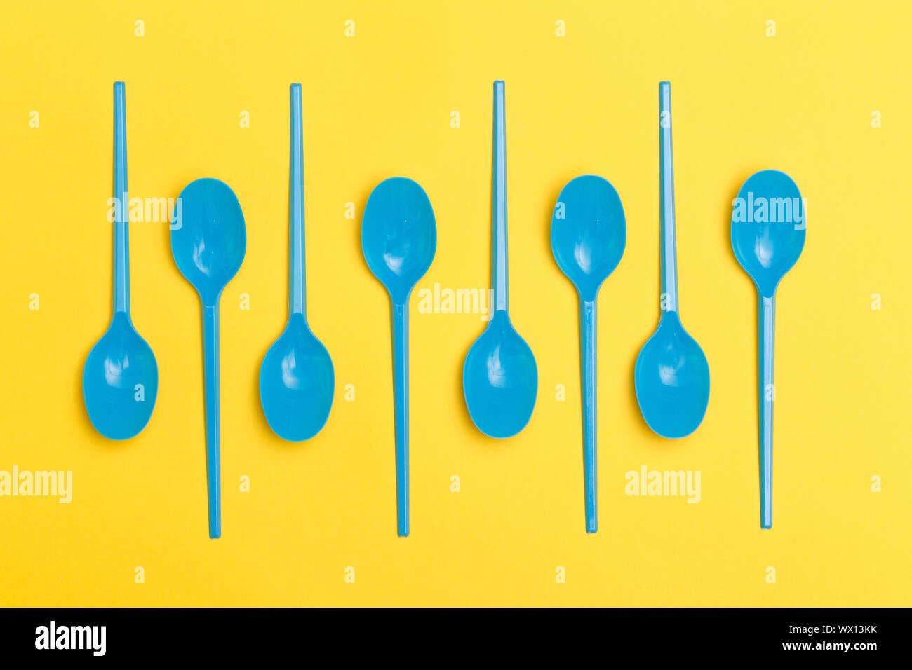 Group of blue disposable plastic spoons over a yellow background Stock ...